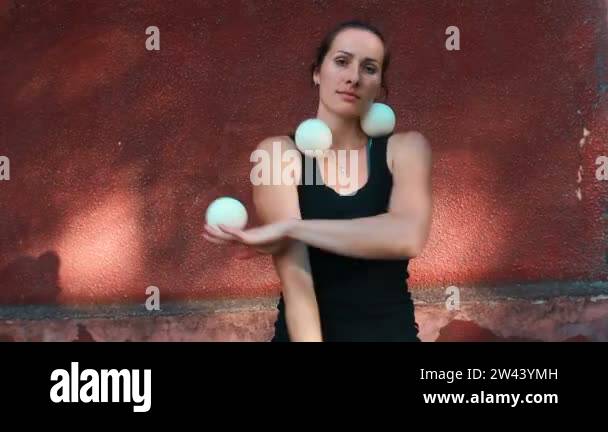 A professional juggler juggles with white balls. A professional circus ...