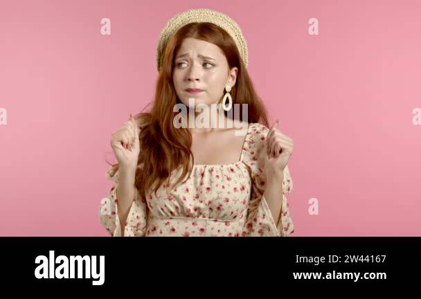 Portrait of young unpleasantly surprised and shocked girl on pink ...