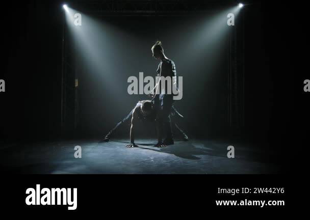 Two gymnastic acrobatic men on balance pose. Silhouettes of strong ...
