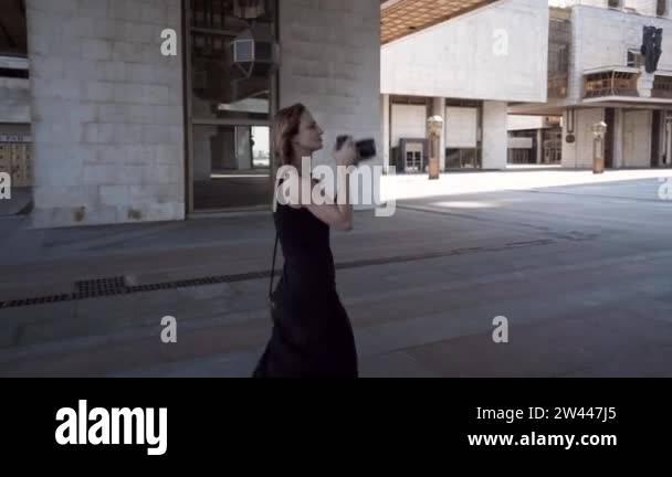 Woman takes photos with camera of architecture of modern buildings ...