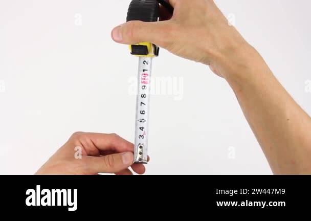 human hands pull the measuring tape out of tape measure and measure the ...