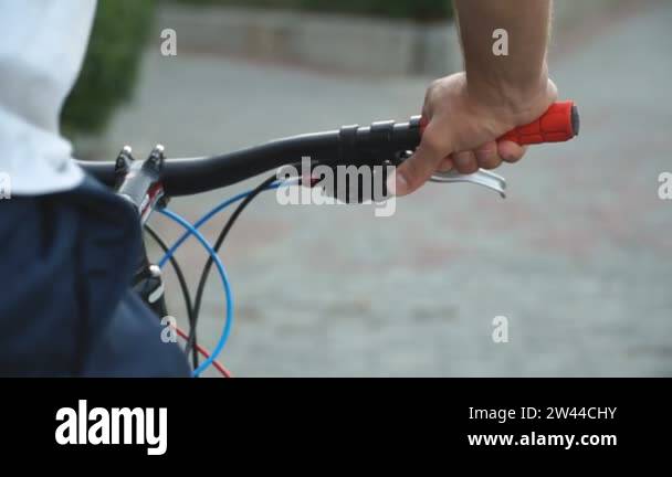 Close up hand of cyclist holding handlebar and driving bike ...