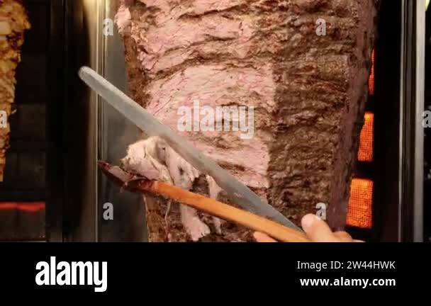 Shawarma meat being cut before making traditional Turkish Doner Kebab ...