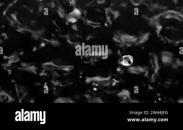 Splashes and drops on the surface of the liquid. Abstract Black ...