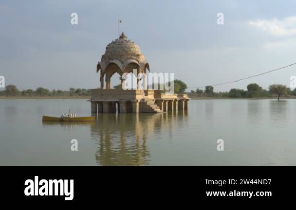 Structures made of yellow stone amidst water body, Gadisar lake in the ...