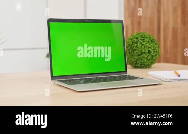 Modern laptop with mock up chroma key green screen on table of living ...