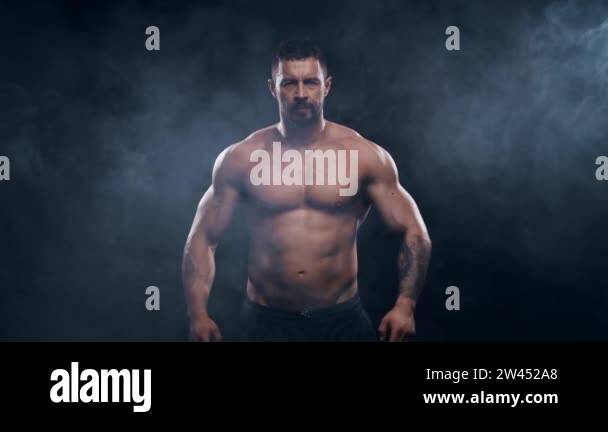 Fit and sporty bodybuilder over black background. Bodybuilder in studio ...