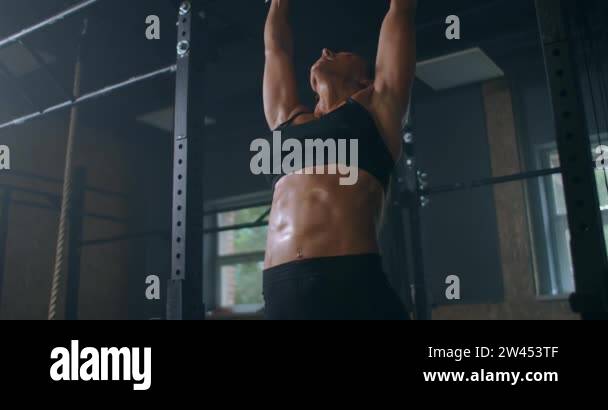 Slow motion: Raising feet up to bar on gym bar, attractive muscle woman ...