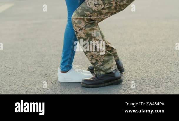 Close up of mal and female legs on road. Man soldier in military ...