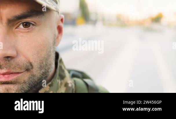 Portrait of Caucasian handsome young man soldier in cap with backpack looking confident at ...