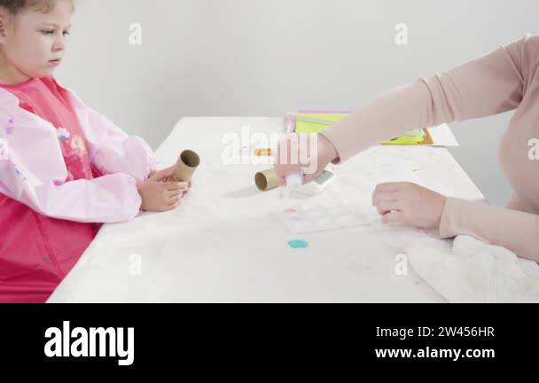 Little girl painting paper mache figurines with acrylic paint for her ...