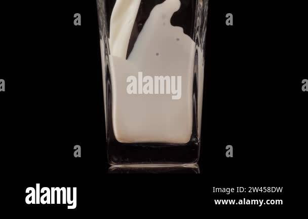 Drink healthy. Super slow motion shot of pouring, splashing fresh milk ...