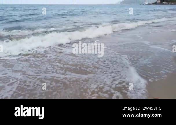 daytime scene during high tide when the sea wave moving onto the sandy ...