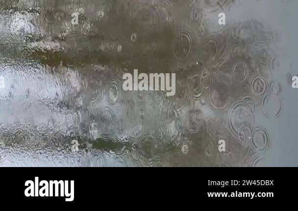 Abstract footage of reflection on water in puddle at rainy weather ...