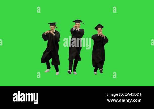 Three male graduates in robes and mortarboards dancing in synch on a ...