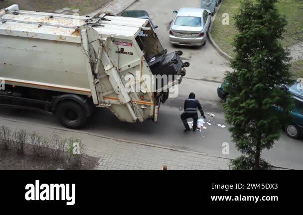 Garbage Truck Car Lifting the Container with Trash. The worker removes ...