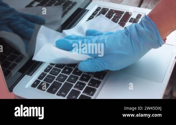 side view virus sanitization on the computer keyboard with blue spray ...