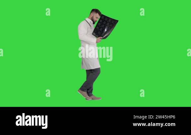 Doctor from middle east walking and looking at ct scan on a Green ...