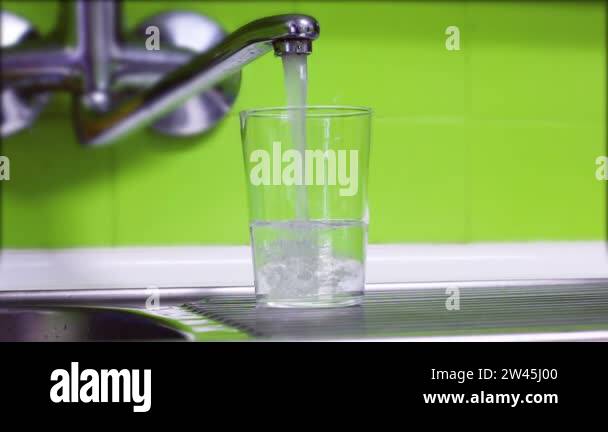 Glass filling to overflowing with clean drinking water until it ...