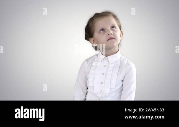 Cute preschool girl standing being shy looking around and thinking on ...