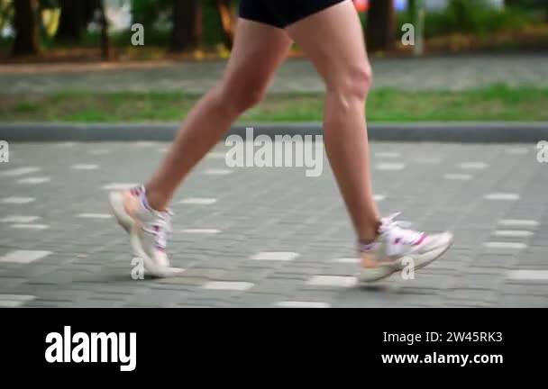 Female athletes feet running at the park. Fitness woman jogging ...