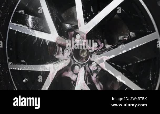 Washing the car wheel rims with neutral pH detergent that removes ...