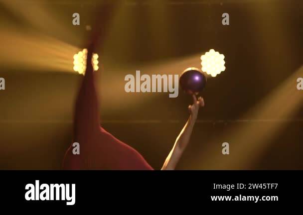 Sports girl gymnast performs acrobatic exercises with ball and does ...