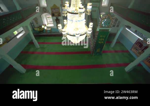 Muslim mosque teacher is reading quran in small historic wooden masjid ...