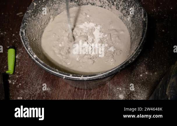 Builder is mixing cement plaster in bucket using an electric mixer ...