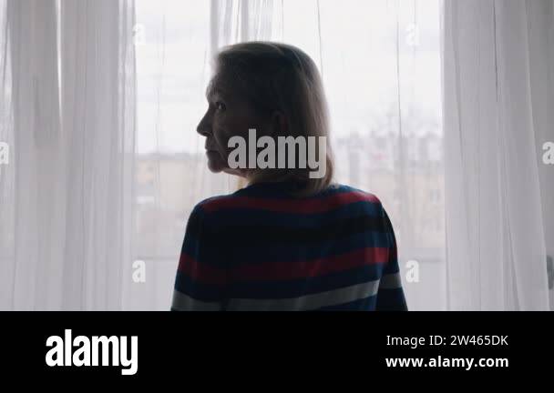 Sad old gray haired woman looking over the shoulder and through the ...