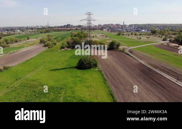 Power pylons and high voltage lines in an agricultural landscape. High ...