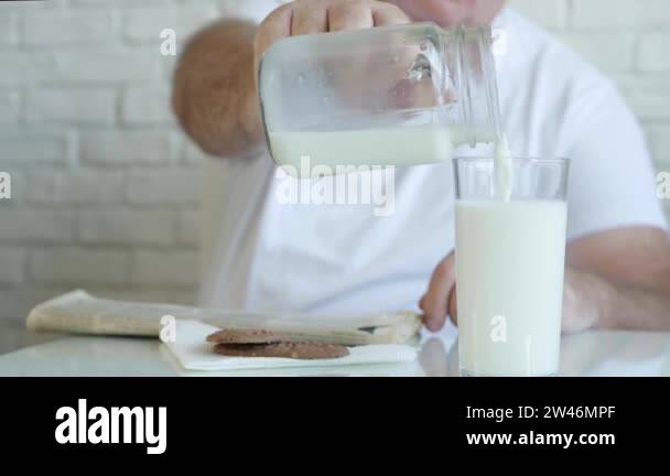 One Person Read a Newspaper and Fill a Glass with Fresh Milk for ...