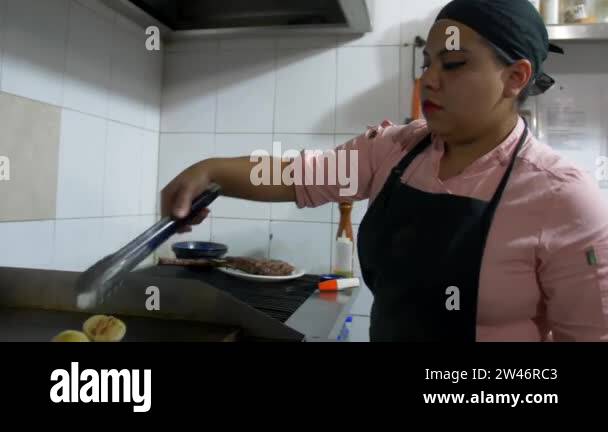 Hispanic female cook frying vegetables in the kitchen Stock Video ...
