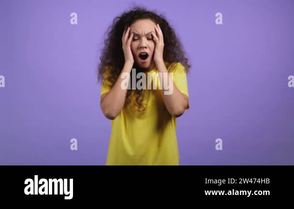 Portrait of unpleasantly surprised and shocked girl on violet studio ...