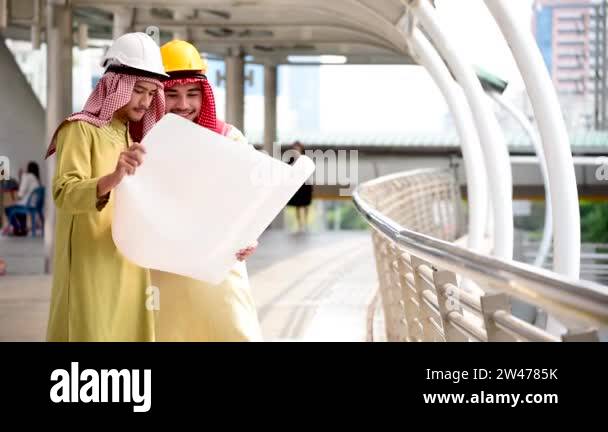 Arab engineer consult construction project together hold blueprint ...