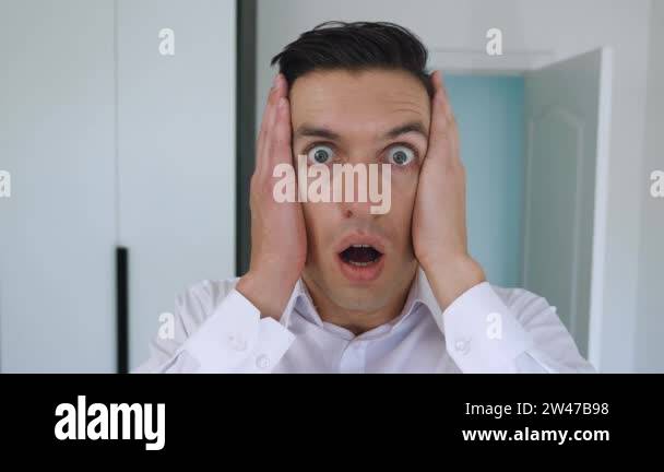 Portrait of scared businessman looks into camera with startle at face ...