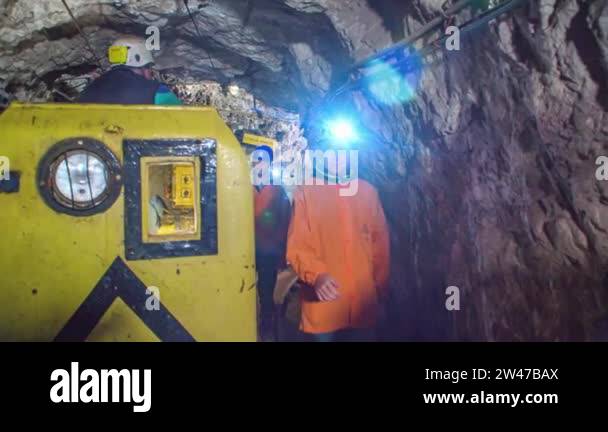 Family walk by train during underground mine tour in Mezica, Slovenia ...