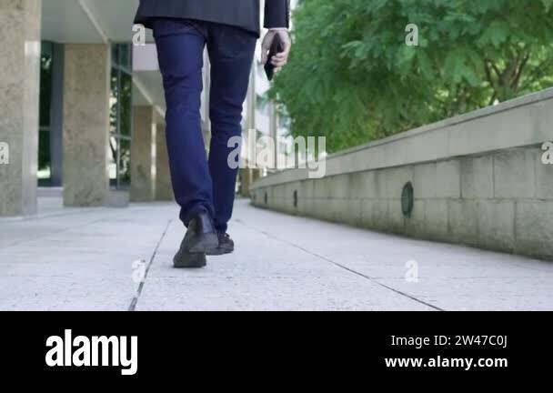 Back view of male legs walking through passage on pavement Stock Video ...