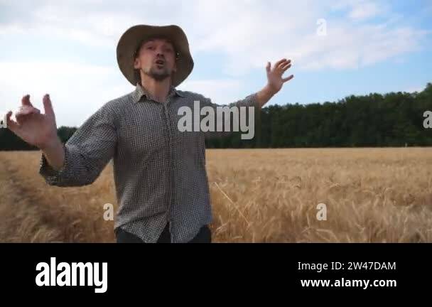 Annoyed farmer running to camera through the wheat field and trying to ...