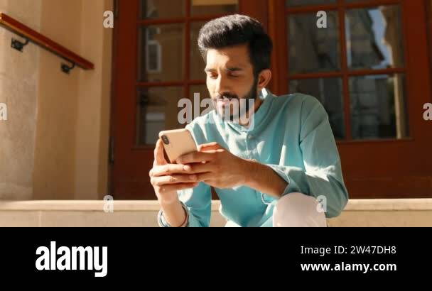 Hindu young handsome man in traditional outfit sitting on steps and ...