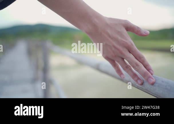 close up light skin female hand touch and sliding over wooden bridge ...