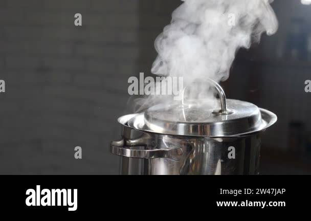 Steam or Vapour clouds rising from boiling water in saucepan on stove ...