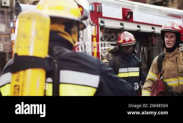 Three firefighters of different races in helmets and gull equipment ...