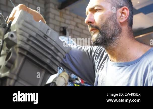 Profile of professional mechanic repairing motor of vehicle. Attentive ...