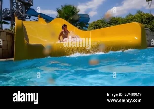 Descent from the waterslide on holiday aqua park. Slow motion on a ...