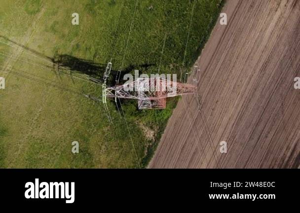 Power pylons and high voltage lines in an agricultural landscape. High ...