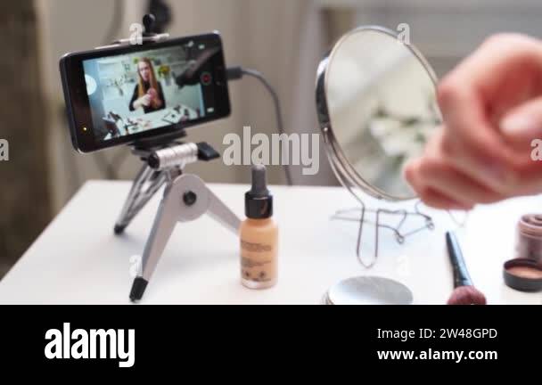 Vlogger female applies lipstick on lips. Beauty blogger woman filming ...