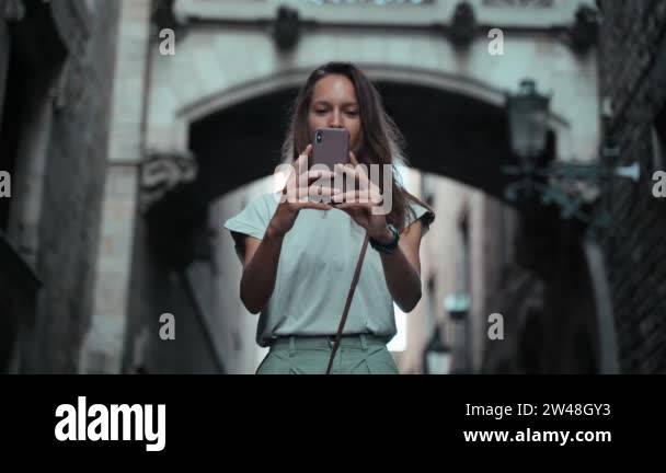 Beautiful long-haired brunette making photo under the arch. Young ...