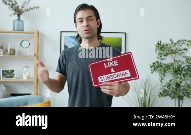 Portrait of young man vlogger holding Like and Subscribe sign and ...