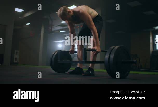 A tired man rests After lifting weights, vilnay exercise deadlifts ...